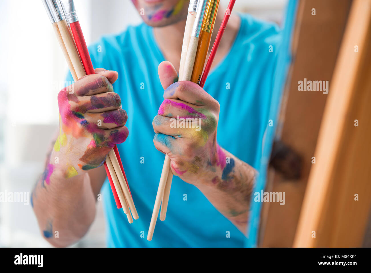 Young funny artist working on new painting in his studio Stock Photo ...