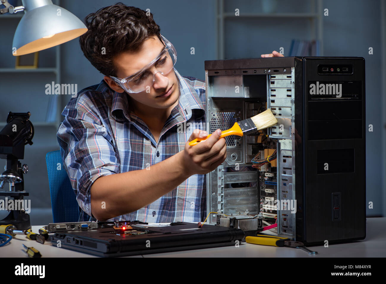 Computer repair man cleaning dust with brush Stock Photo - Alamy