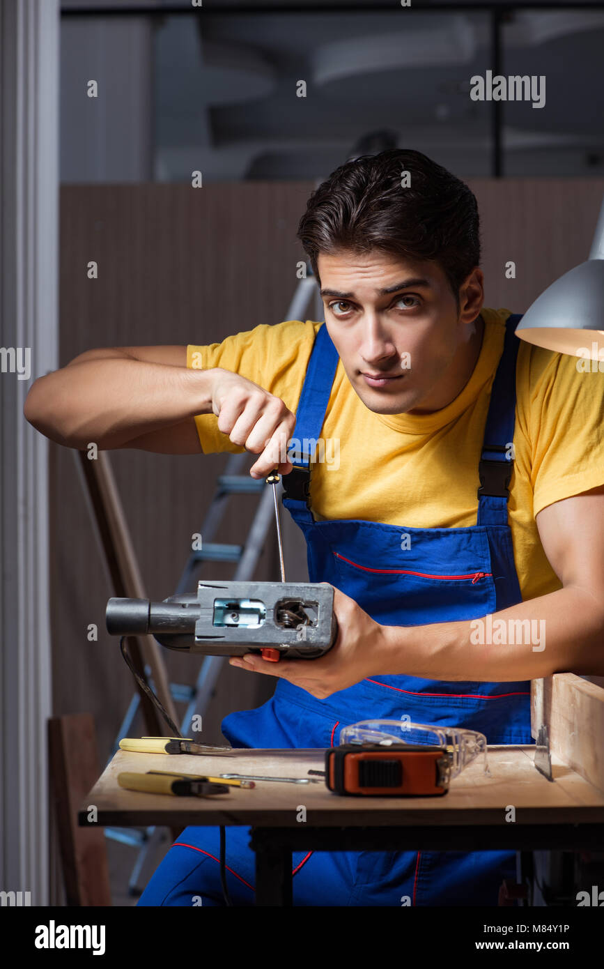 Worker working in repair workshop in woodworking concept Stock Photo ...