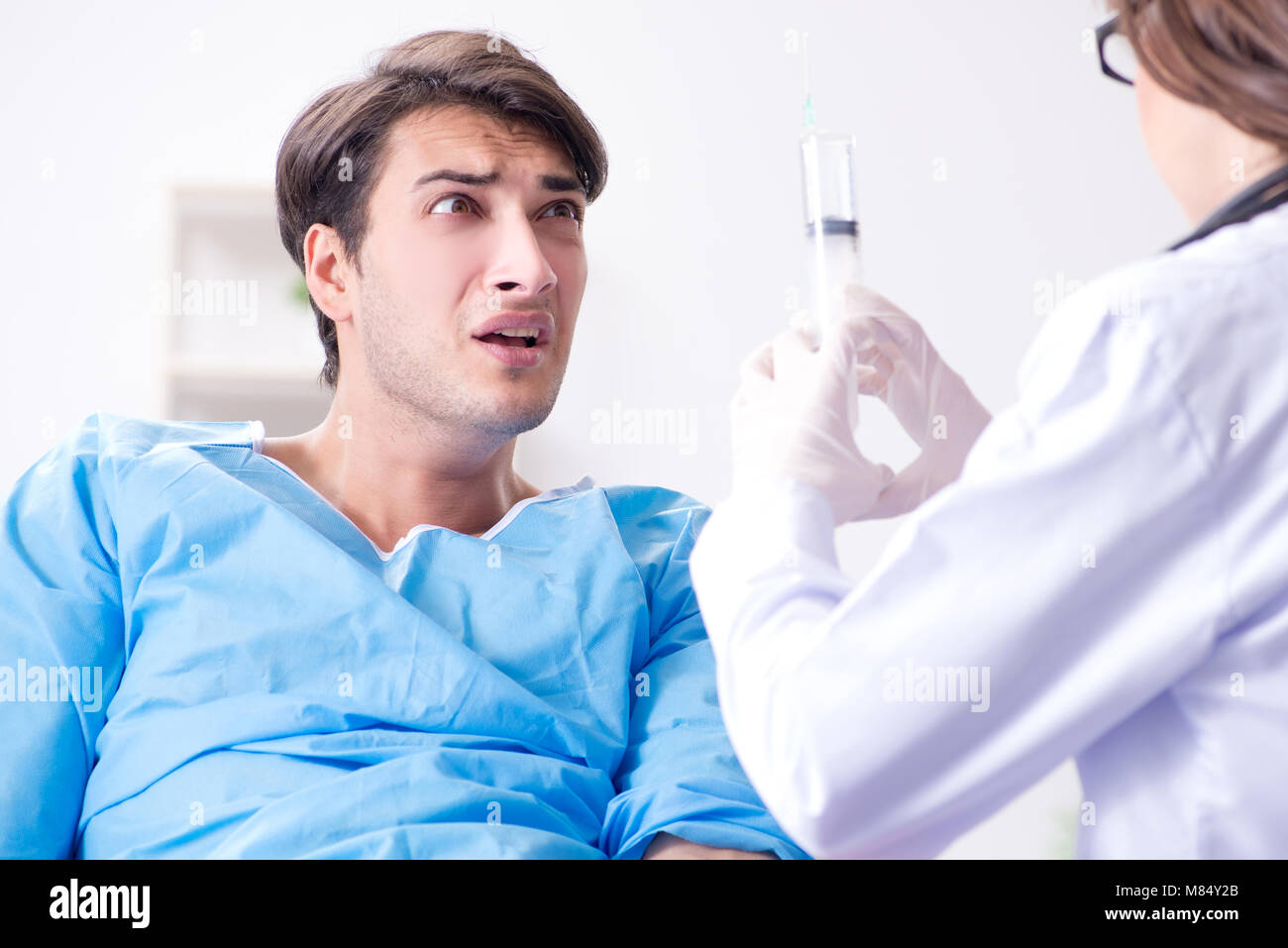 Scared patient man getting ready for flu shot Stock Photo - Alamy