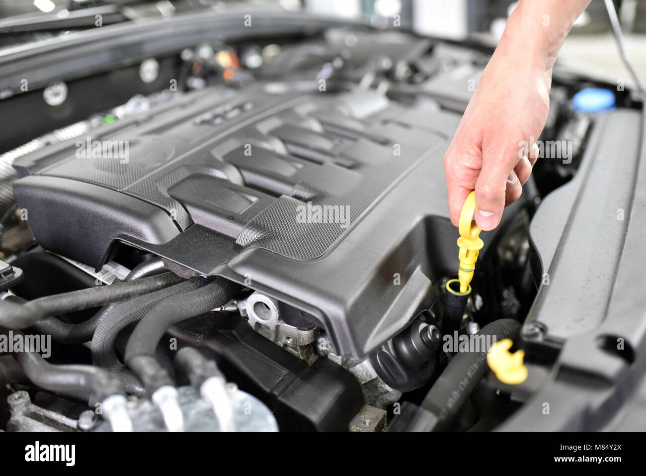oil level control of the car engine by mechanics in a car workshop ...