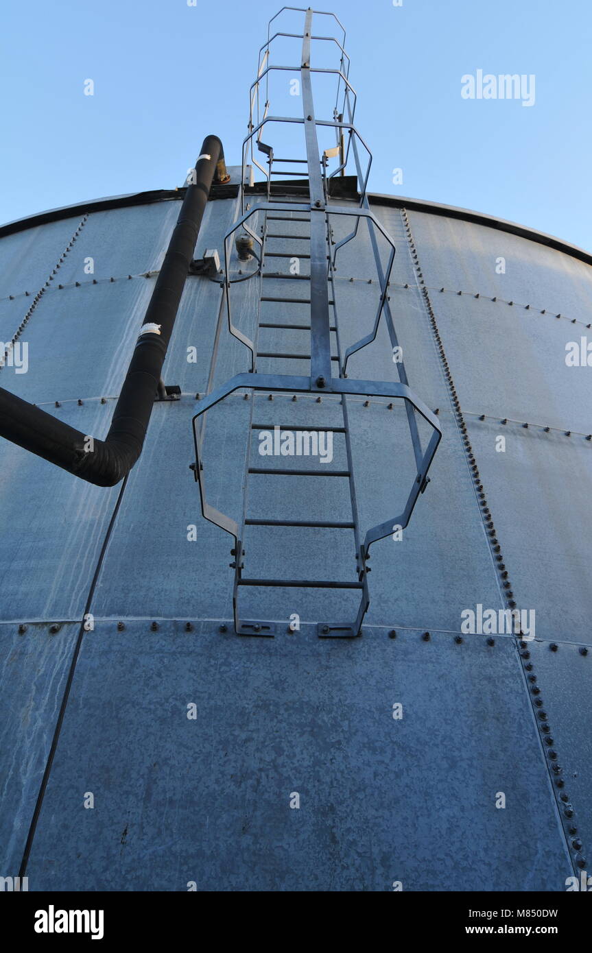 industrial silo or gas holder with a ladder and pipe Stock Photo - Alamy