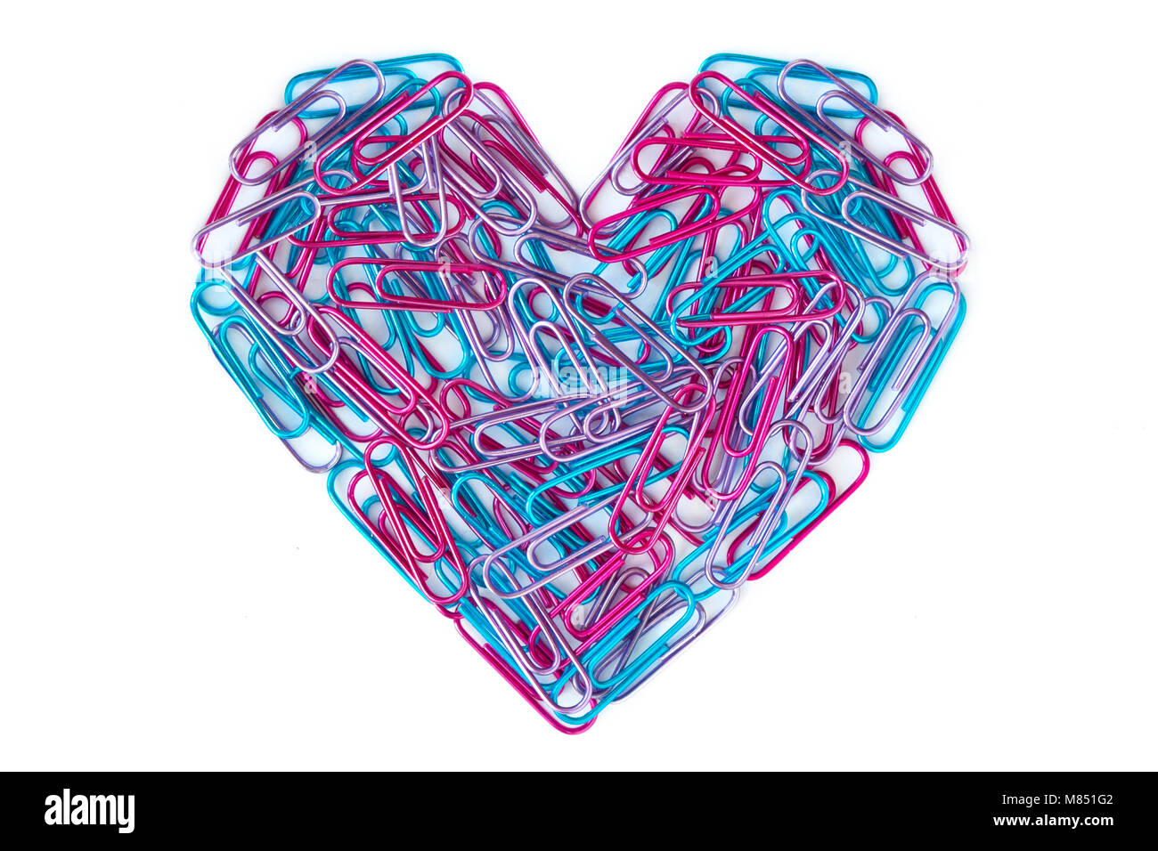 Blue and pink paper clips arranged in heart shape on white background ...