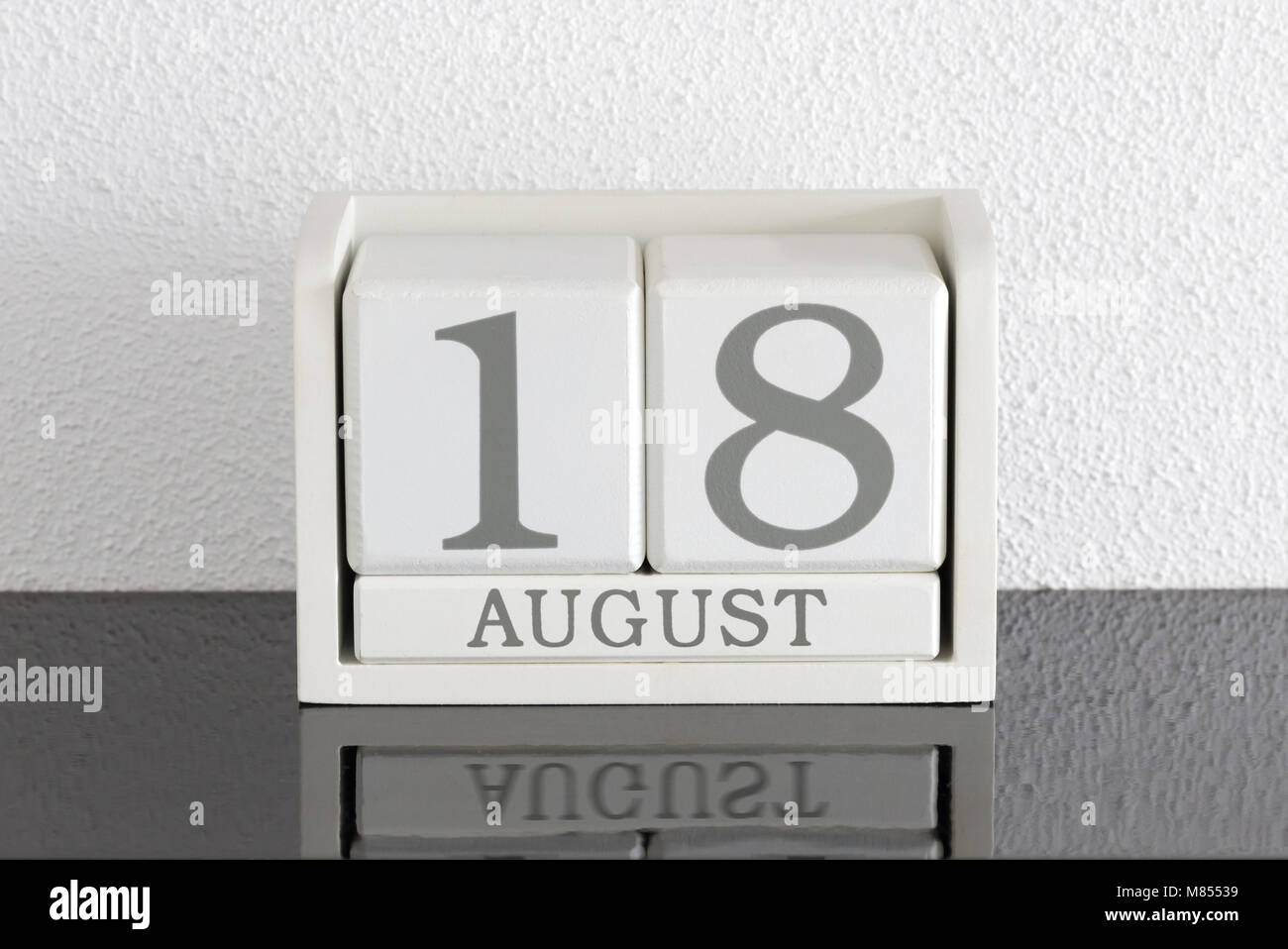 White block calendar present date 18 and month August on white wall ...