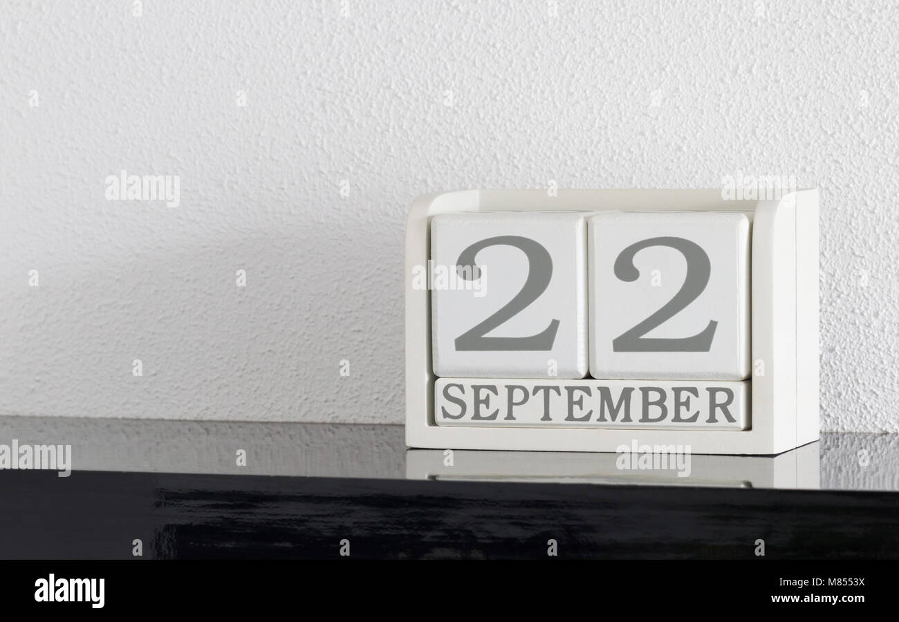 White block calendar present date 22 and month September on white wall ...