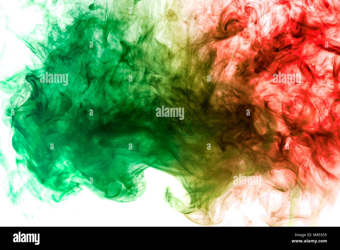 Dense multicolored smoke of red, green and yellow colors on a white ...