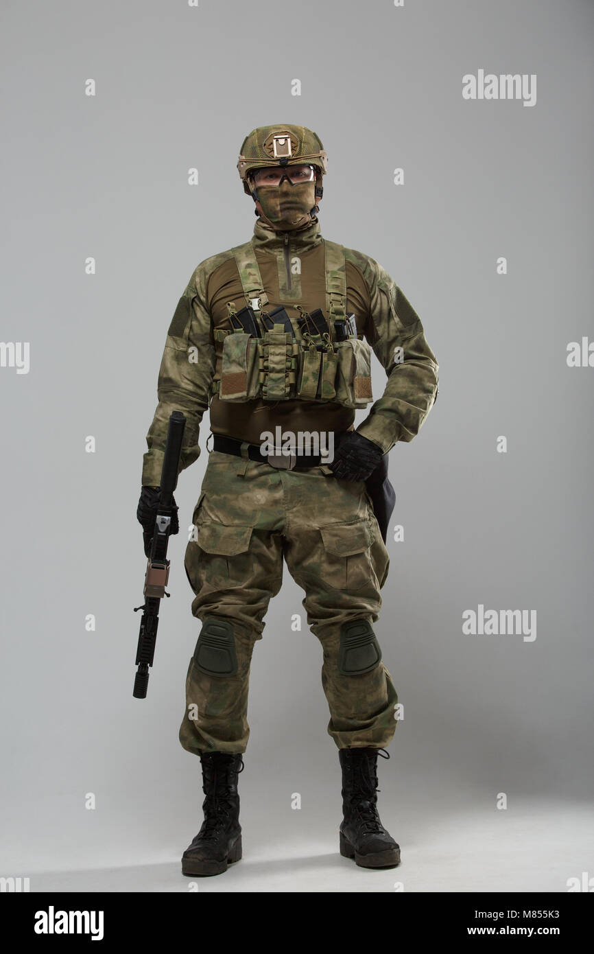 Full-length photo of military man with gun Stock Photo - Alamy