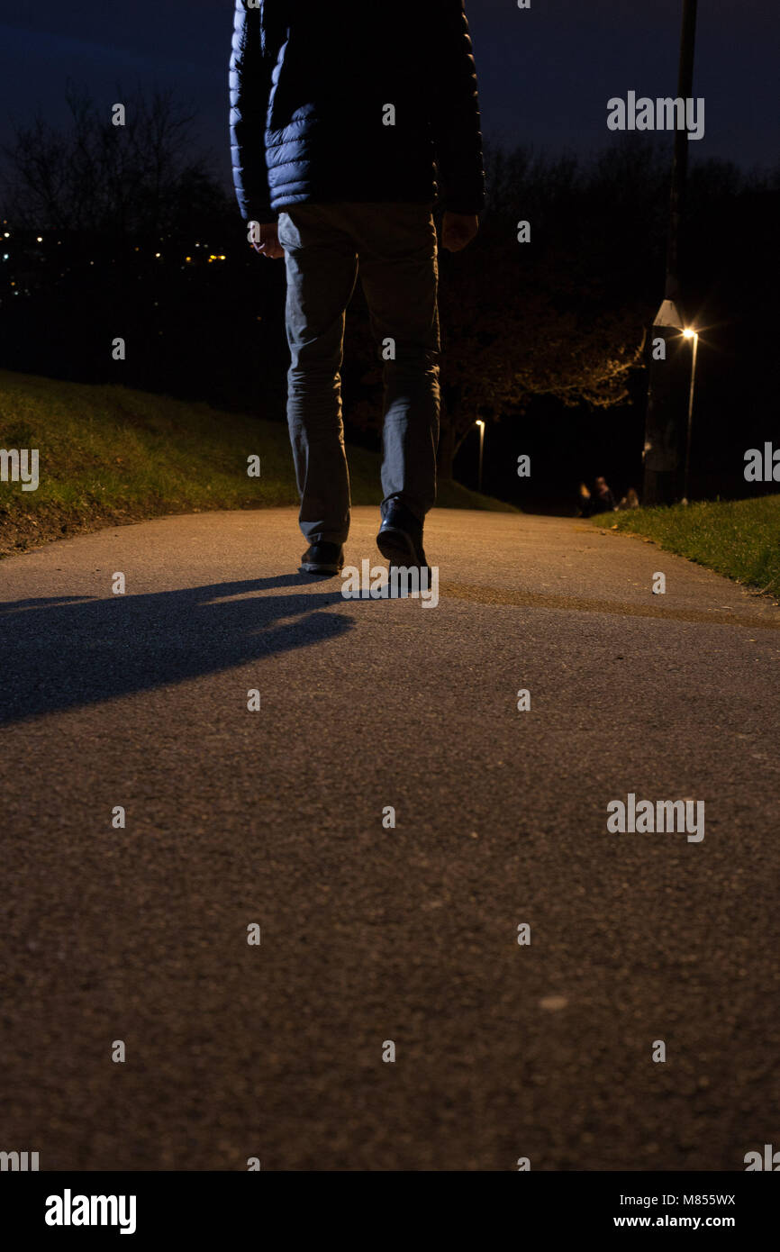 Back view of a man walking into the distance. Lower body shot Stock ...