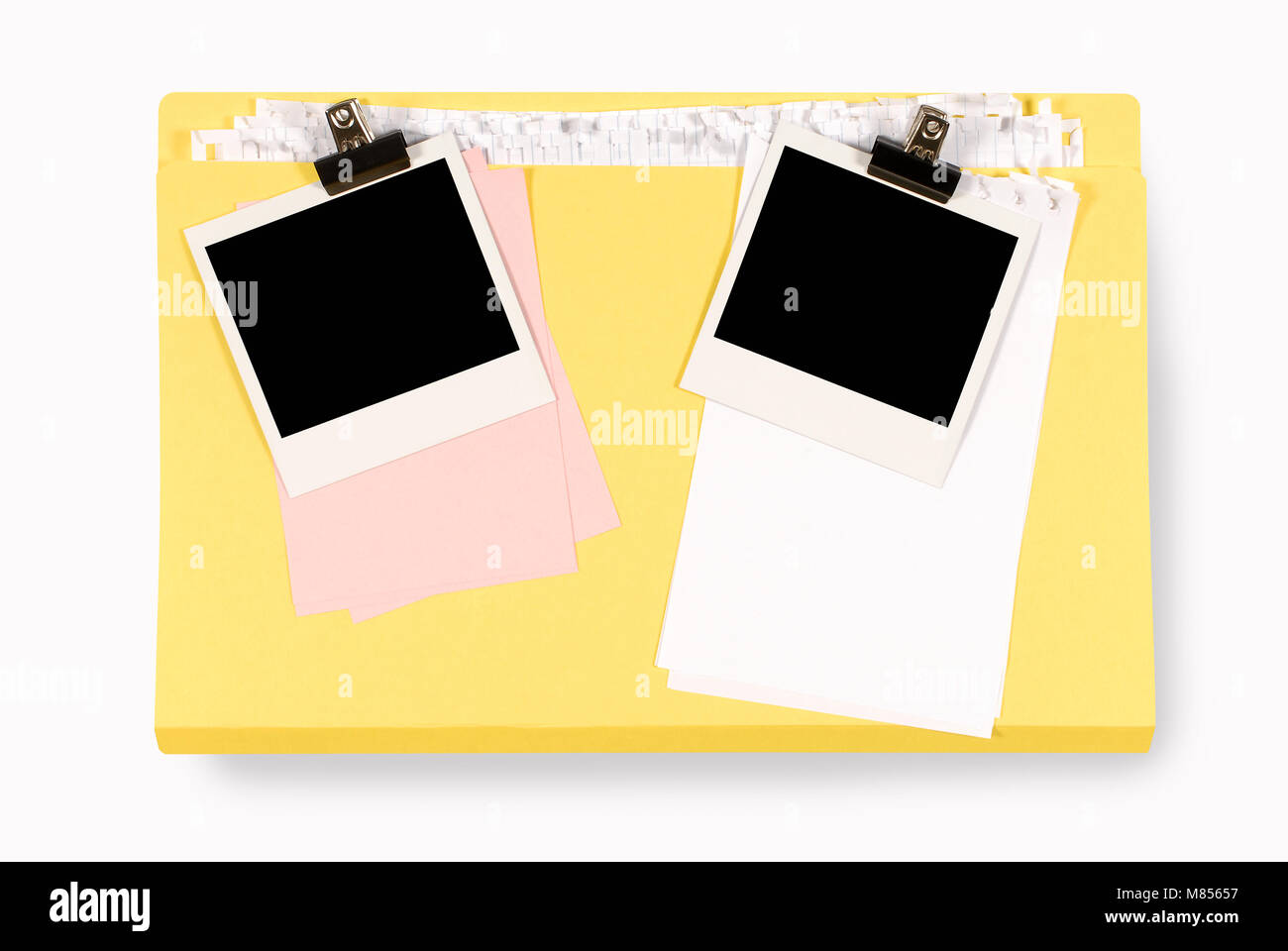 Office folder with untidy note paper and blank instant camera photo ...