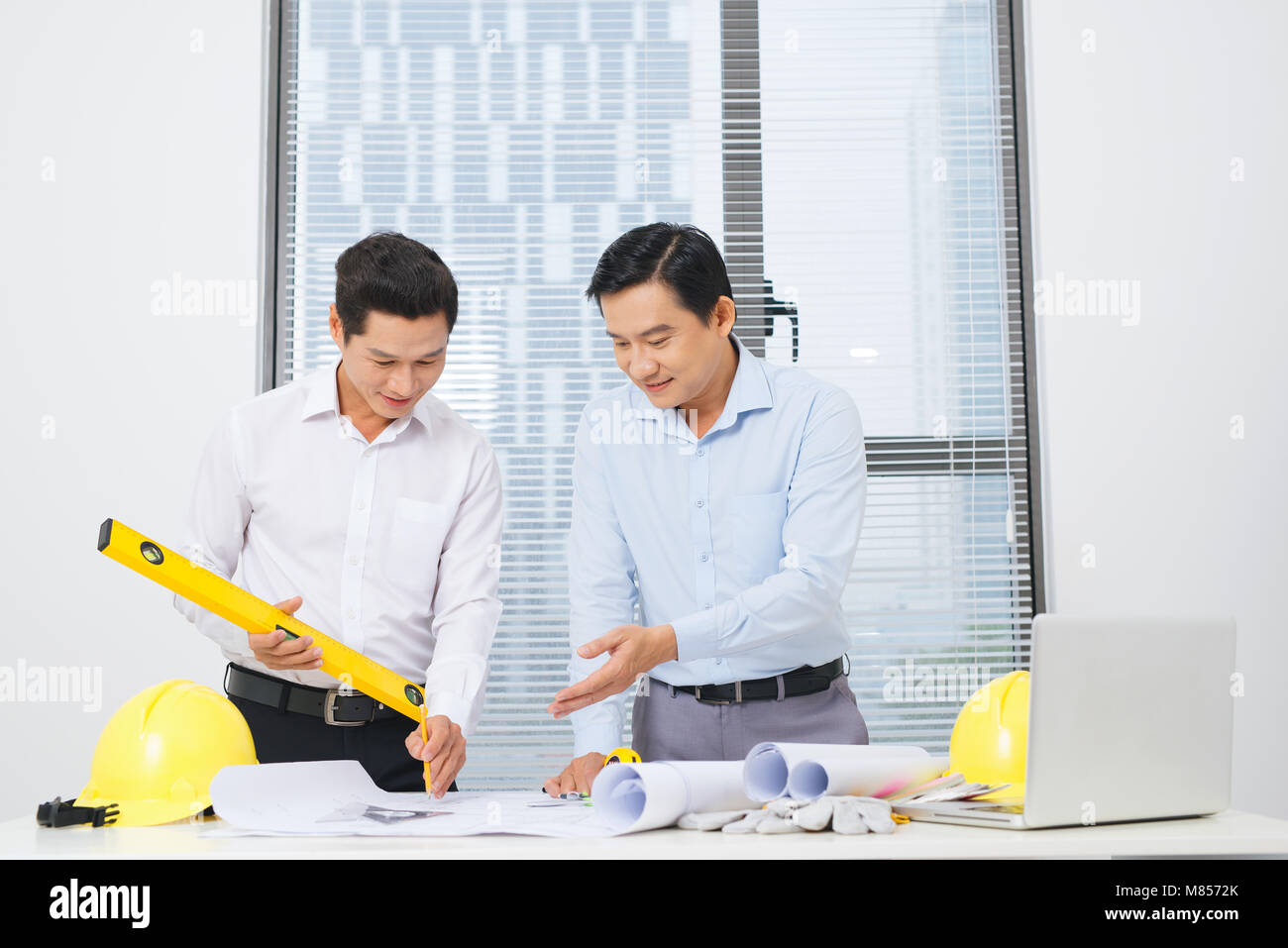 Architects engineer discussing at the table with blueprint of ...