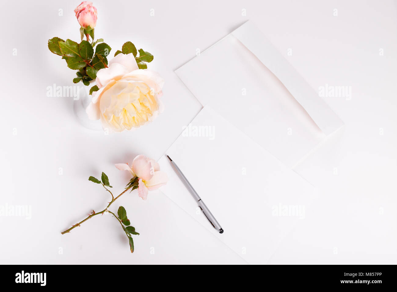 Letter, pen and white envelope on white background with pink english ...
