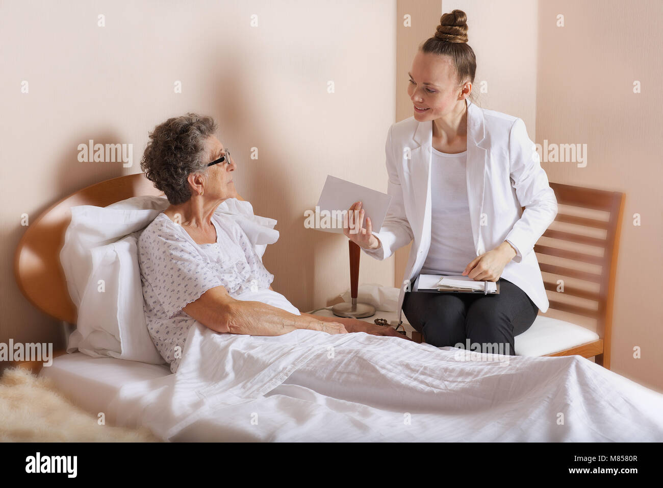 Old woman with senior social work assistant Stock Photo - Alamy