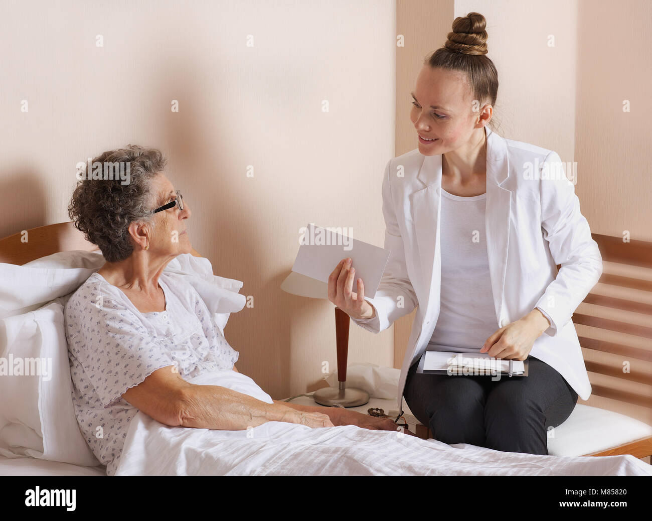 Old woman with senior social work assistant Stock Photo - Alamy