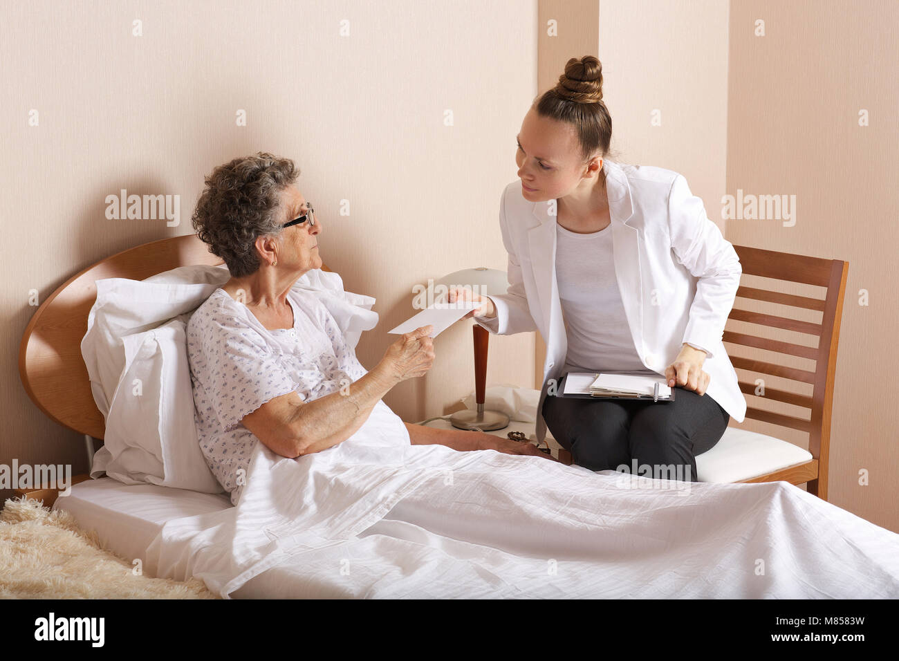 Old woman with senior social work assistant Stock Photo - Alamy