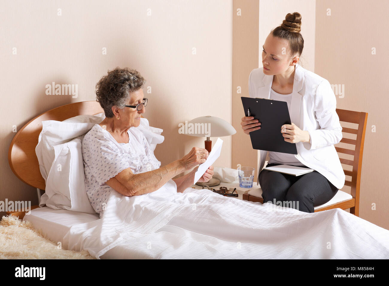 Old woman with senior social work assistant Stock Photo - Alamy
