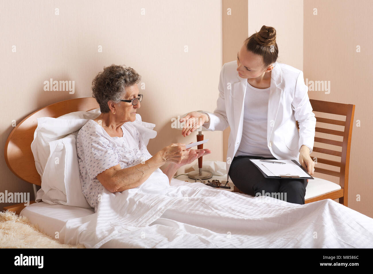 Old woman with senior social work assistant Stock Photo - Alamy