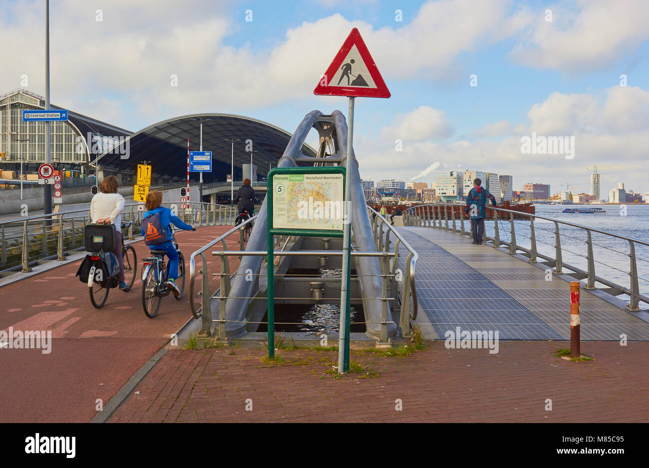 Cycle lanes next to the IJ river with Amsterdam Central Station in the ...