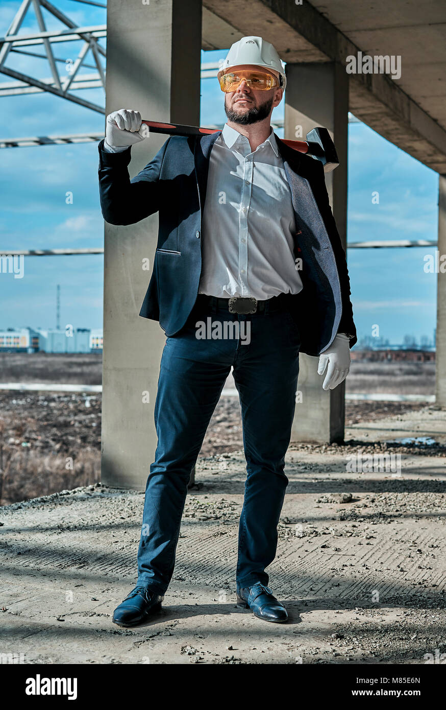 Builder in a helmet on construction object Stock Photo - Alamy