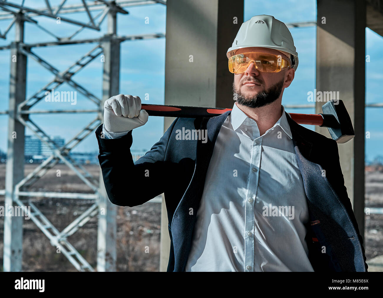 Builder in a helmet on construction object Stock Photo - Alamy