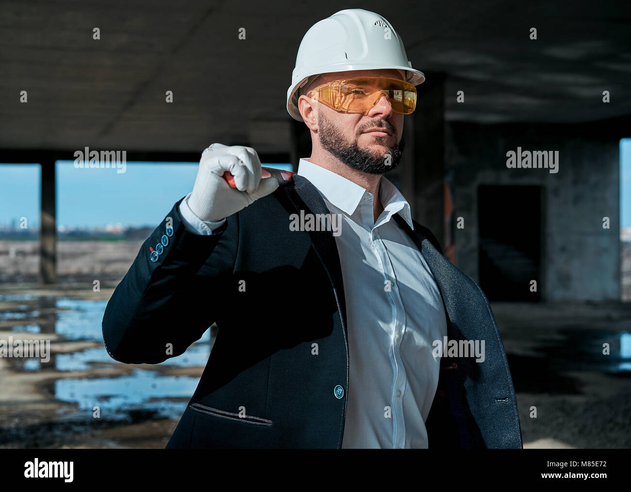 Builder in a helmet on construction object Stock Photo - Alamy