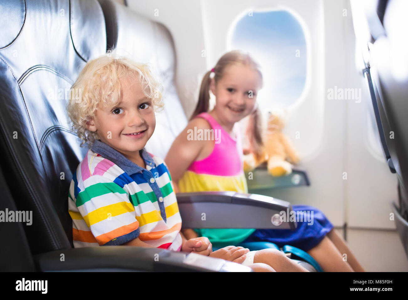 Child in airplane. Kids sit in air plane window seat. Flight ...
