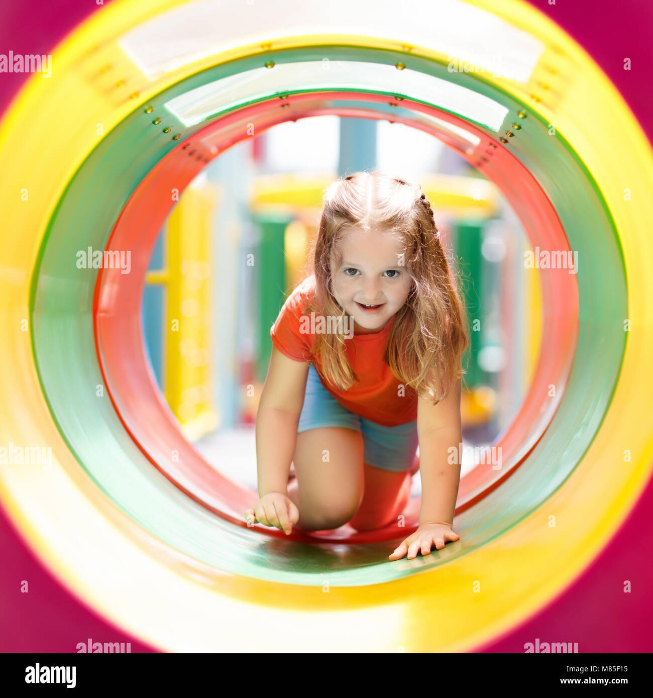 Kids climbing and sliding on outdoor playground. Children play in sunny ...