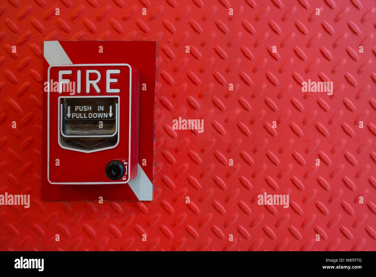 Fire alarm hand lever red on red diamond steel background Stock Photo ...