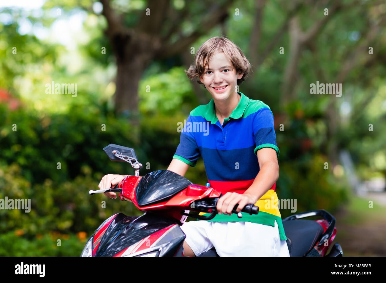 Teenager riding scooter. Teenage boy fun on motorbike ride on his way ...