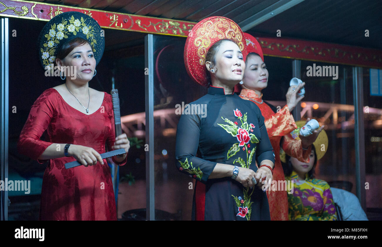 Vietnamese traditional singers on a boat. Using Sinh Tien (coin clapper ...