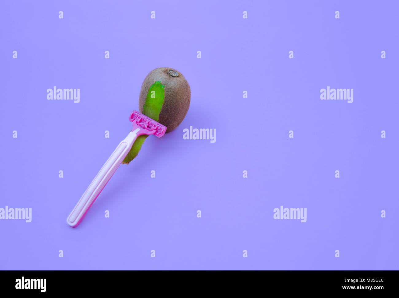 Kiwi fruit and razor on violet background. Hair removal concept Stock ...