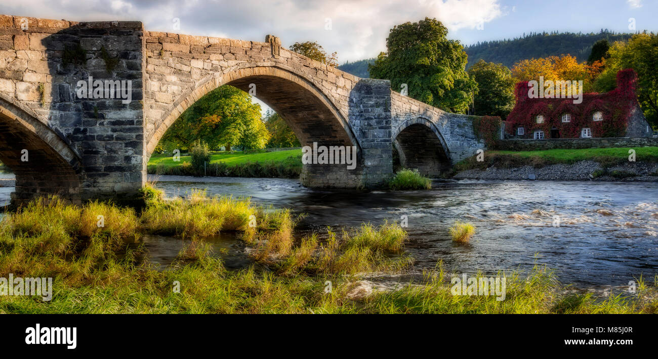 Old stone arch bridge and cottage in autumn colours at Llanwrst, Wales ...