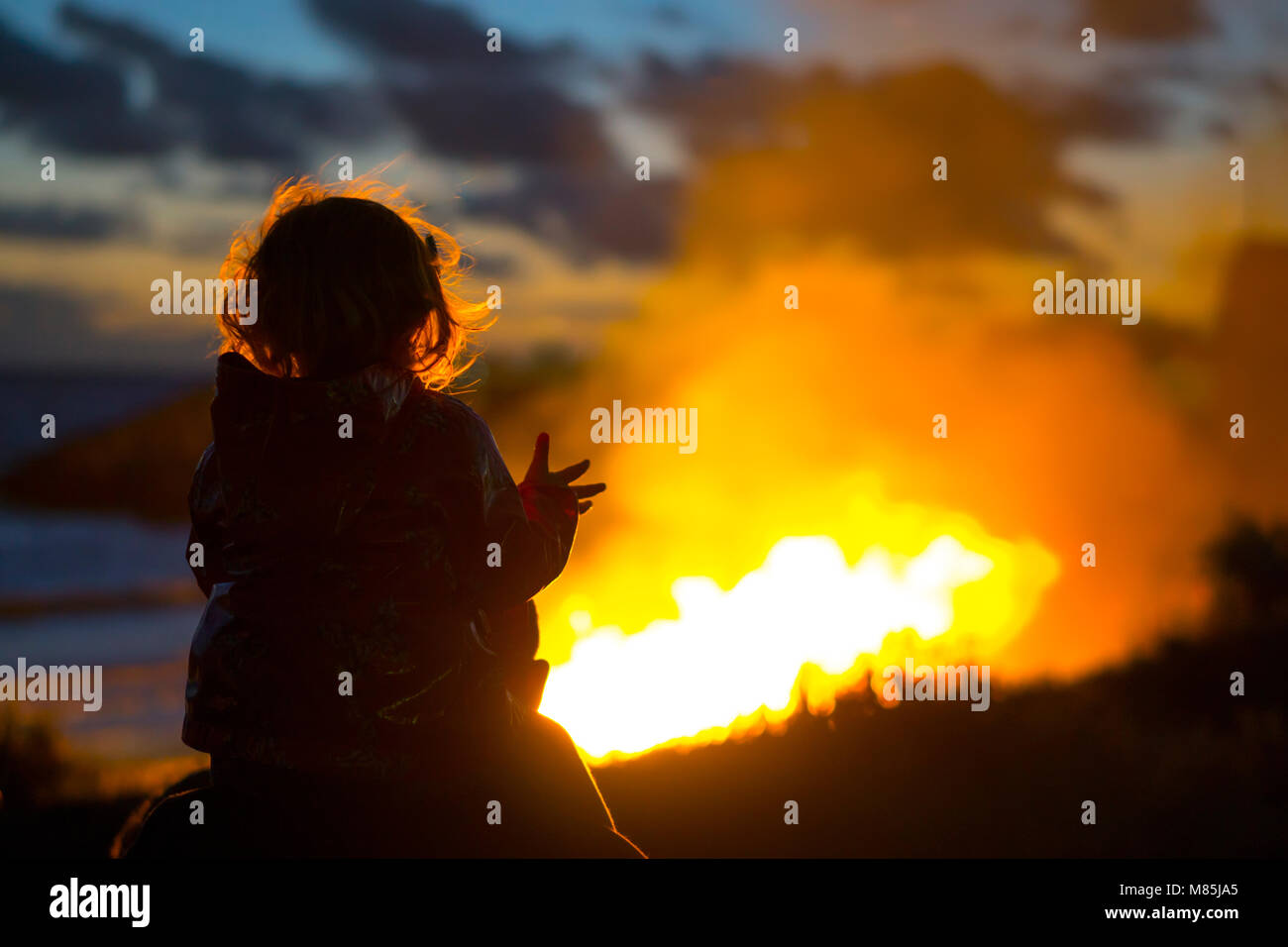 Small child watching bonfire on beach Stock Photo - Alamy