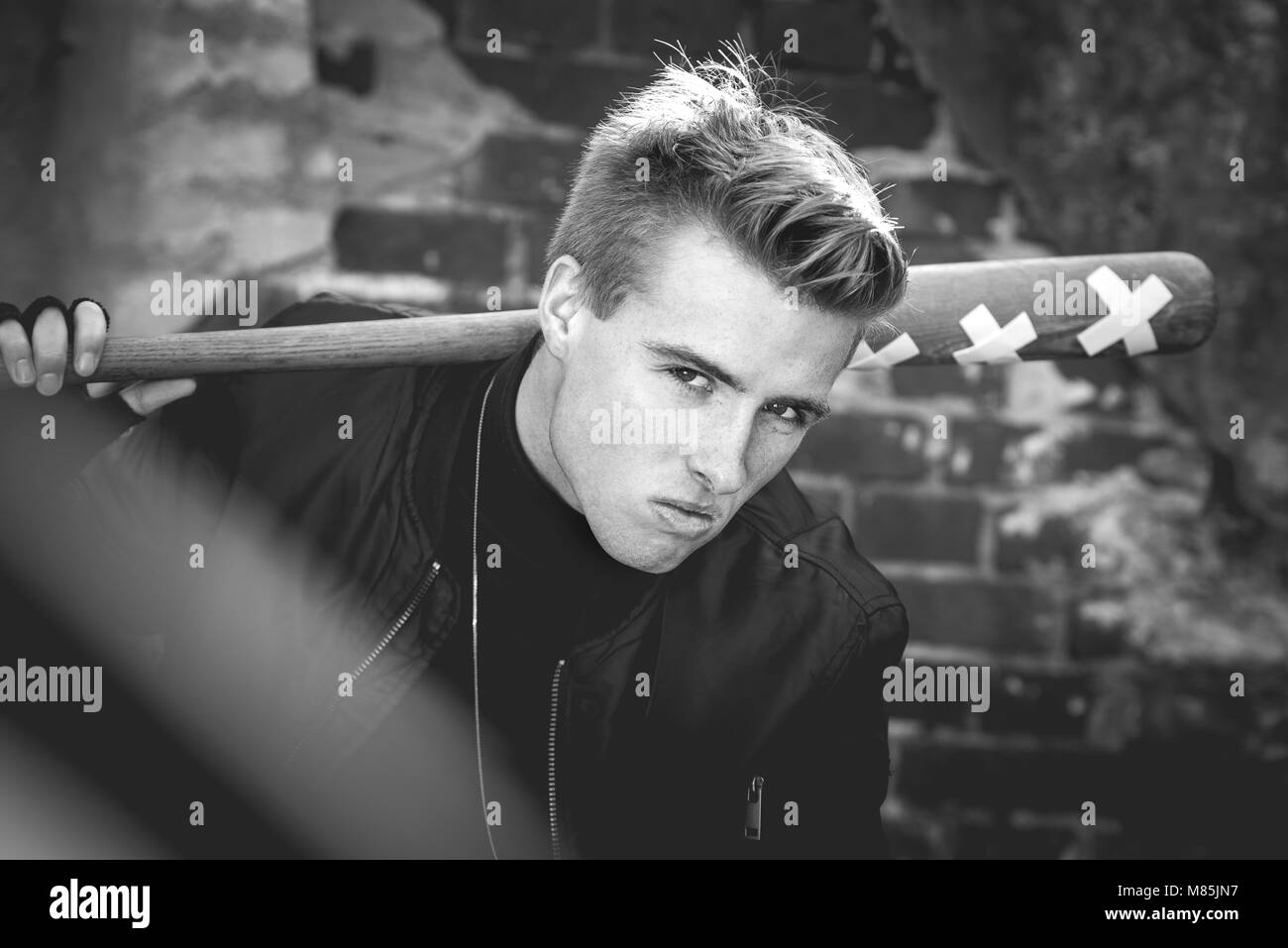 Aggressive blond haired hooligan with baseball bat with nice hairstyle ...