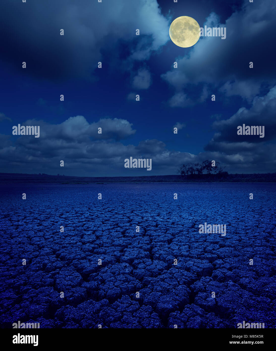 full moon in clouds over cracked earth Stock Photo - Alamy