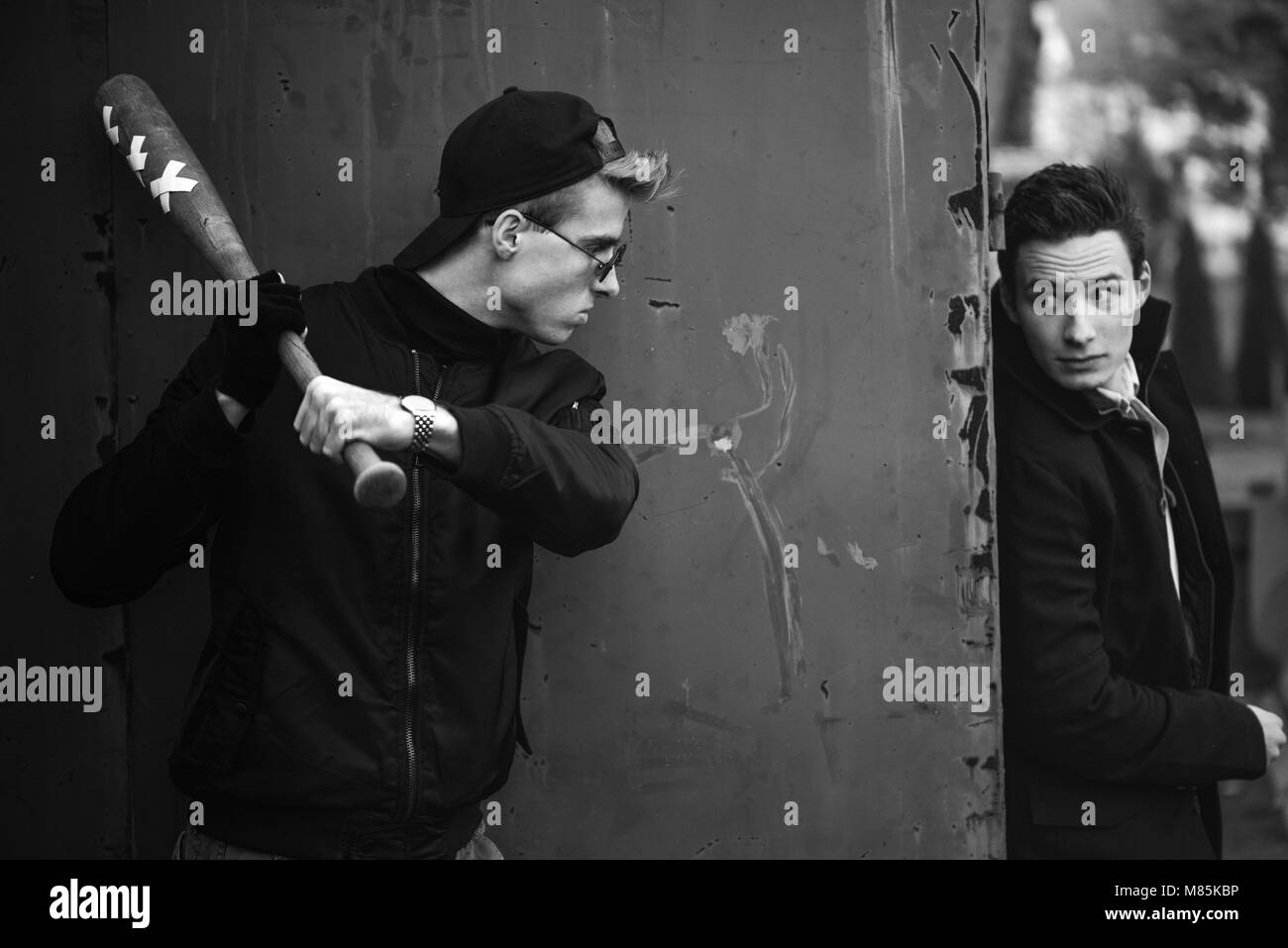 hooligan with the baseball bat in hands ready to attack from hiding ...