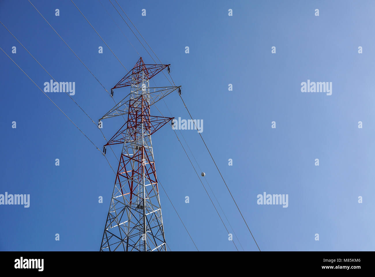 High Voltage Power Lines intersect at a large metal Utility pole in ...
