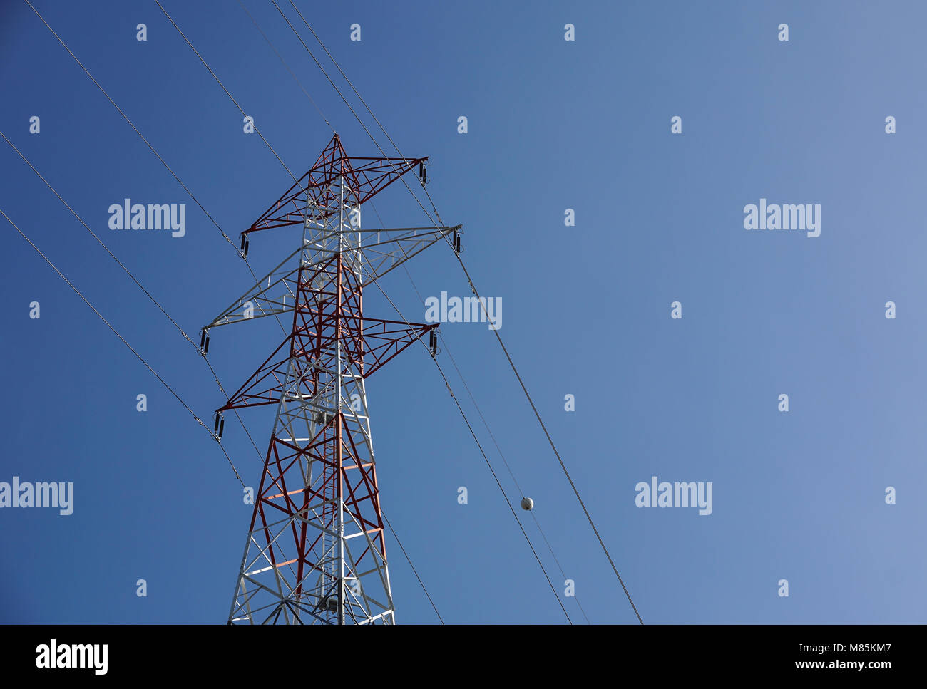 High Voltage Power Lines intersect at a large metal Utility pole in ...