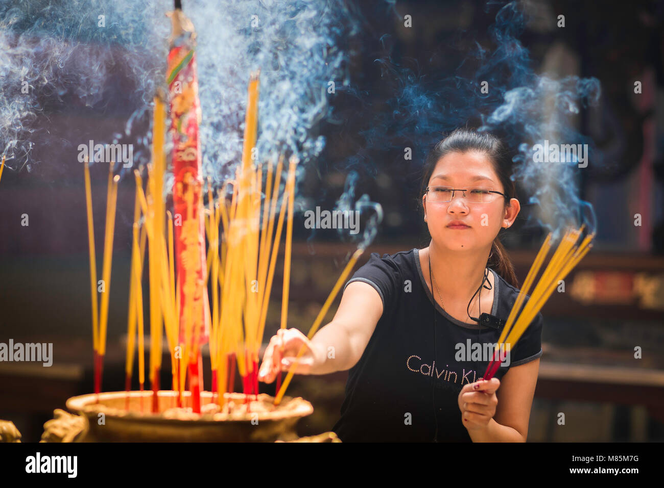 Woman prayer Southeast Asia, view of a young woman praying in the Thien ...