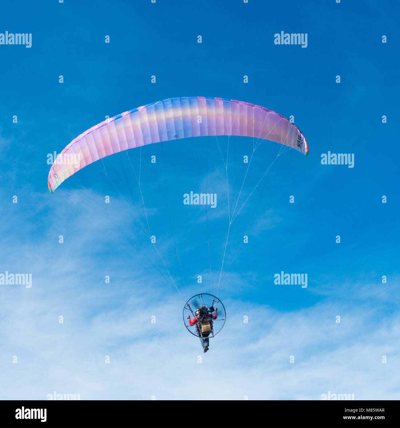 Motorized paraglider against blue sky Stock Photo - Alamy