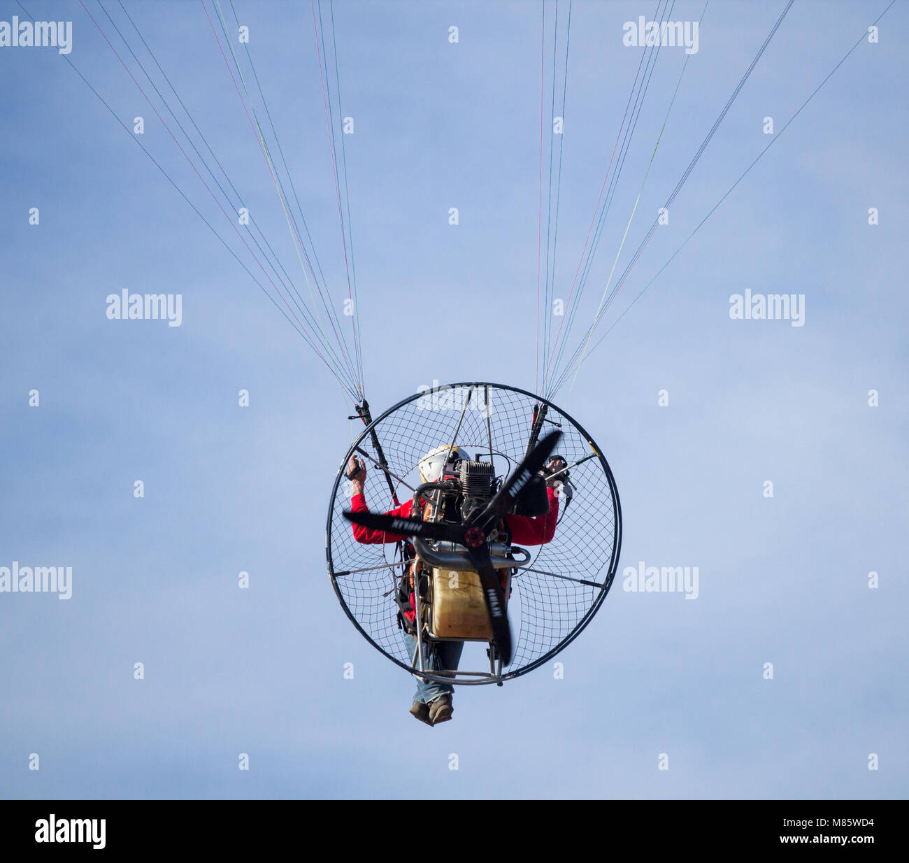 Motorized paraglider against blue sky Stock Photo - Alamy