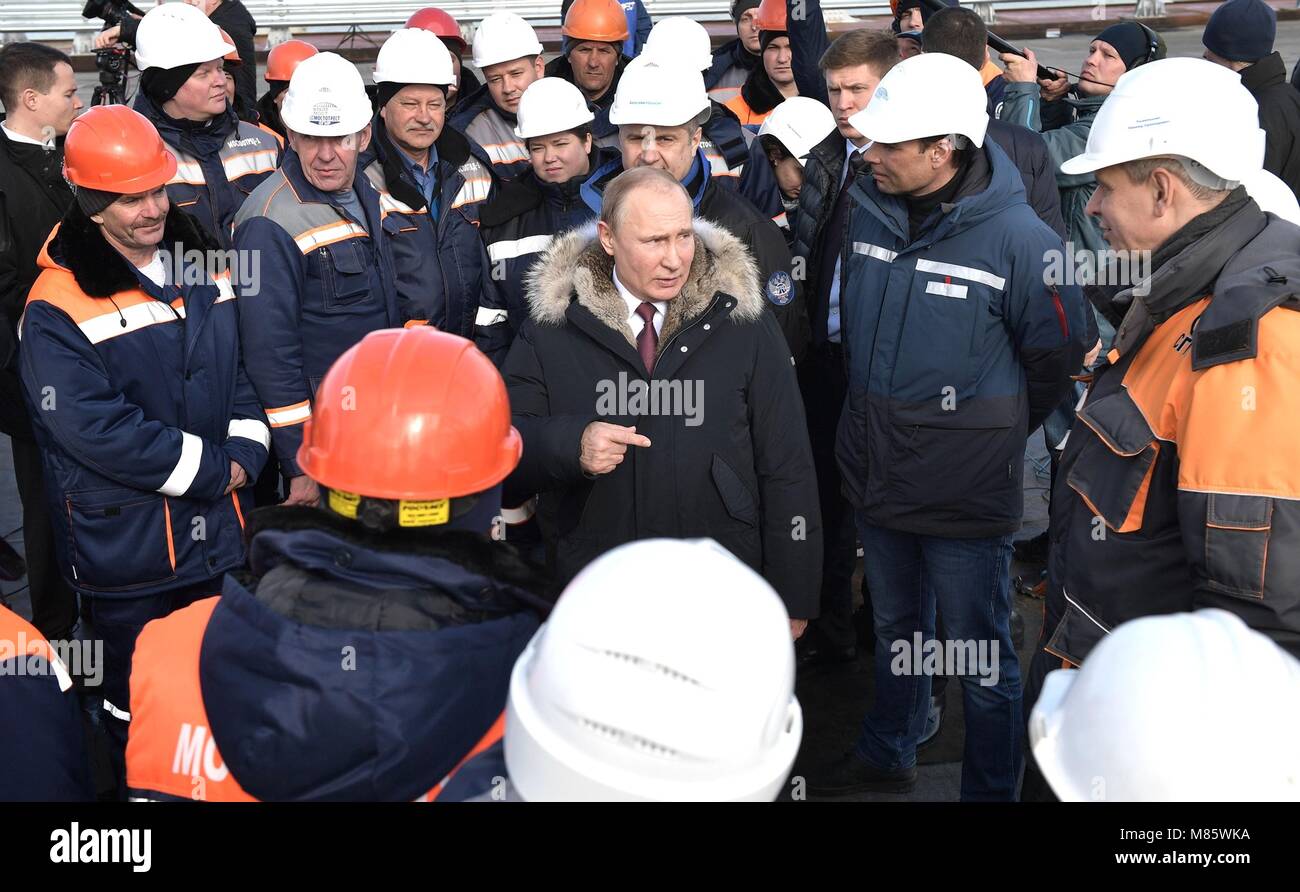 Russian President Vladimir Putin talks with workers during a tour of ...