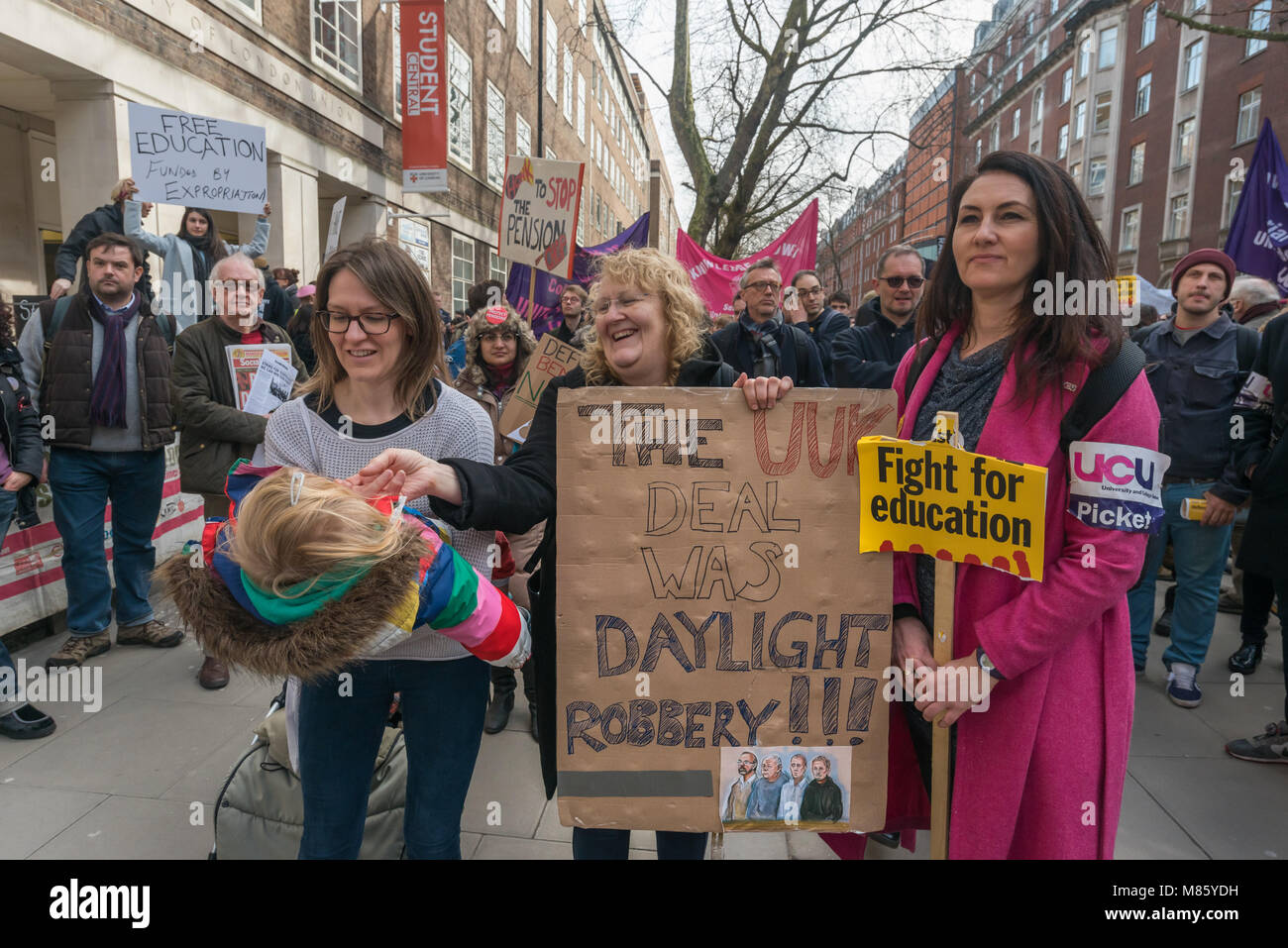London, UK. 14th March 2018. People stand with placards and and a ...