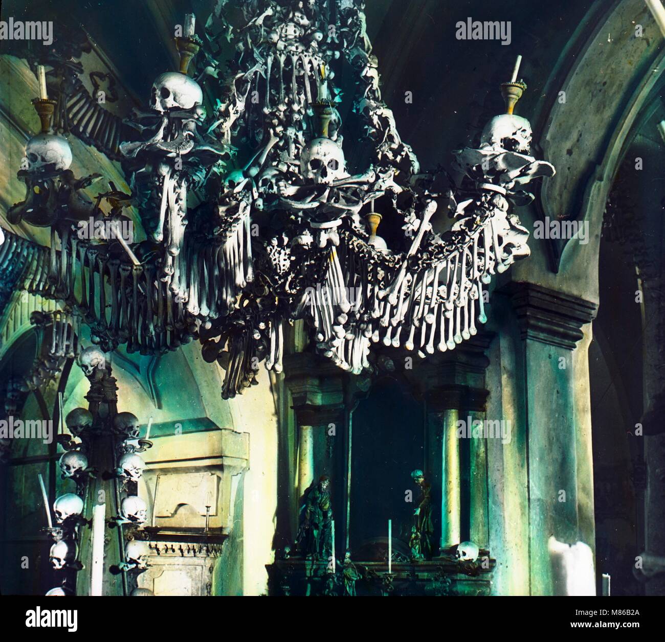 Colorized photo of a chandelier made of skulls and bones in the Sedlec ...