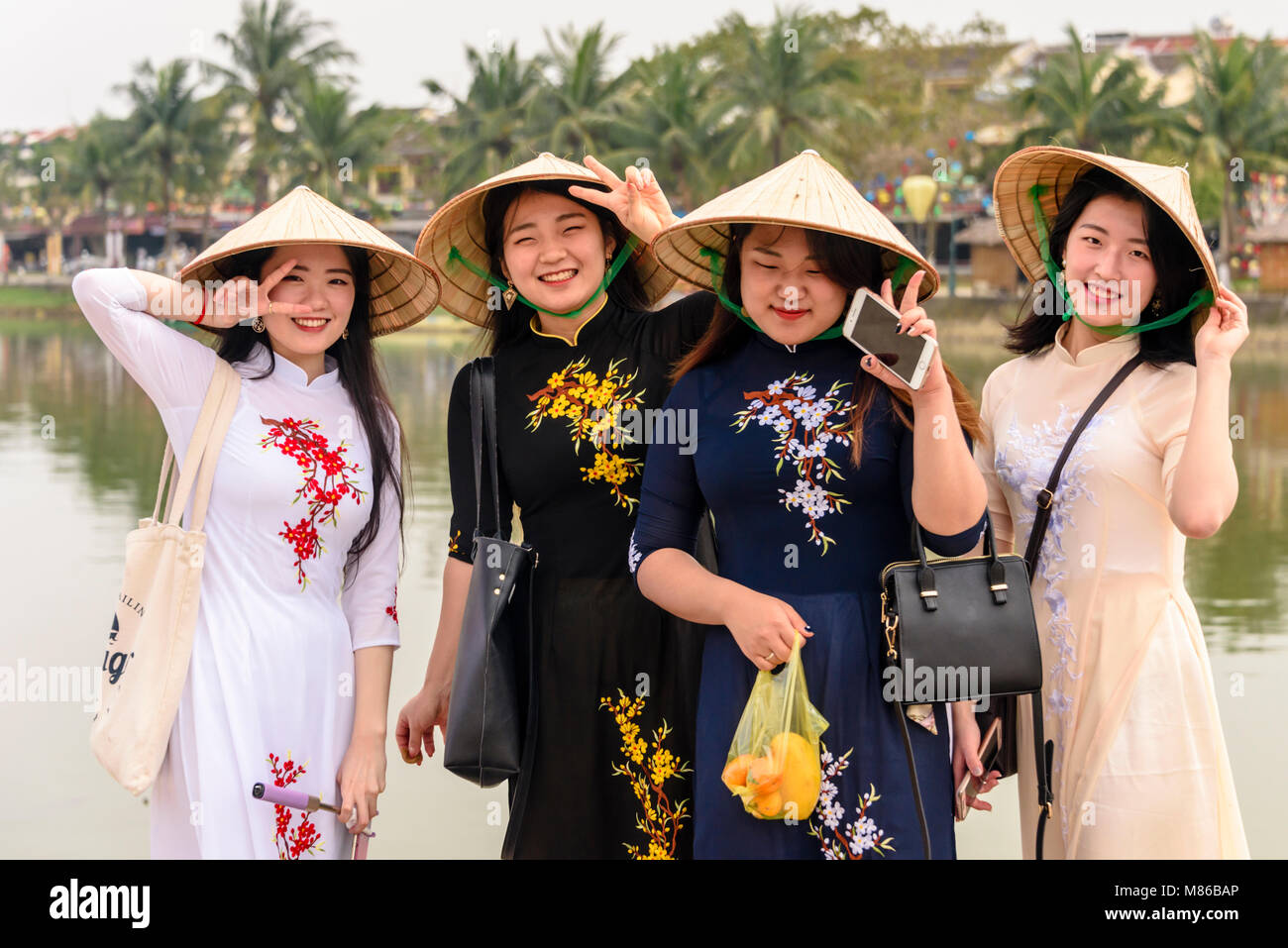 Four young ladies wearing traditional Vietnamese bamboo conical hats in ...