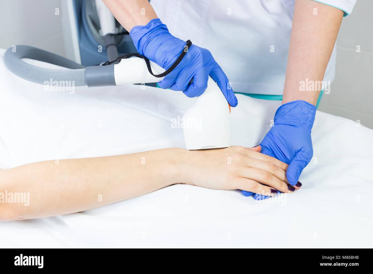 The process of laser depilation of female limbs in the beauty salon ...