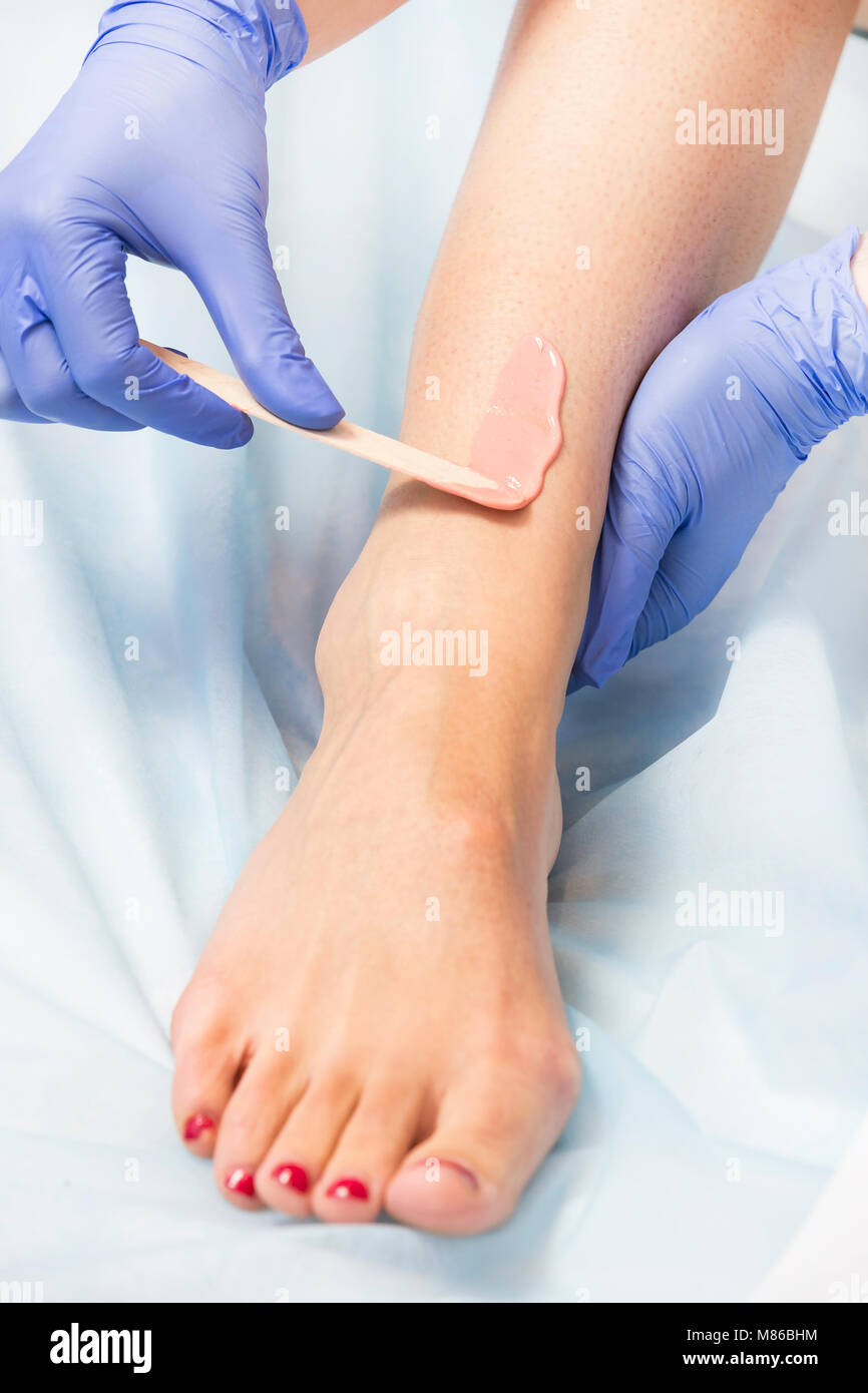The process of classical wax depilation of female limbs in the beauty ...