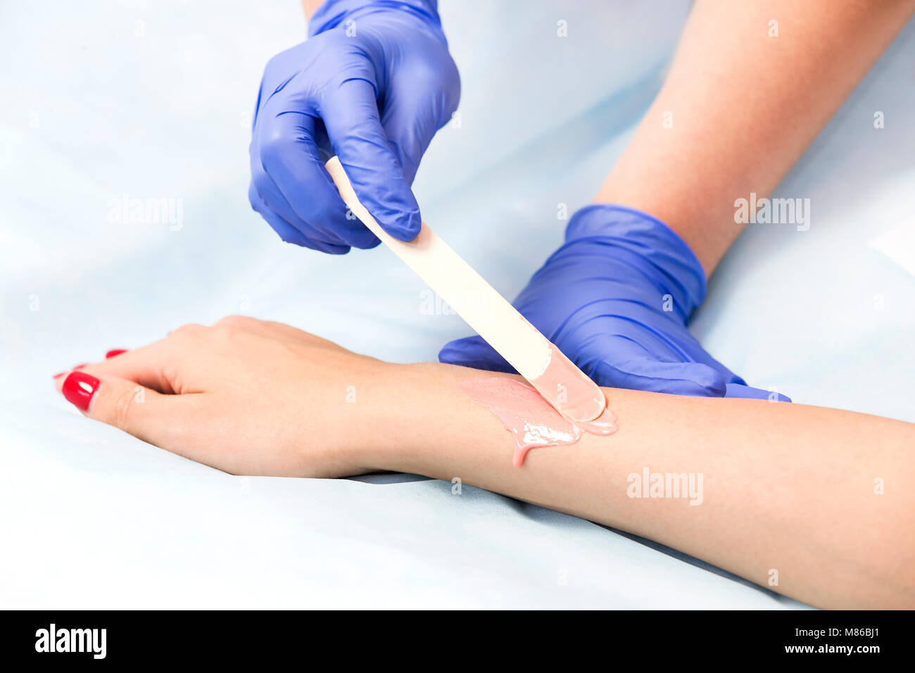 The process of classical wax depilation of female limbs in the beauty ...