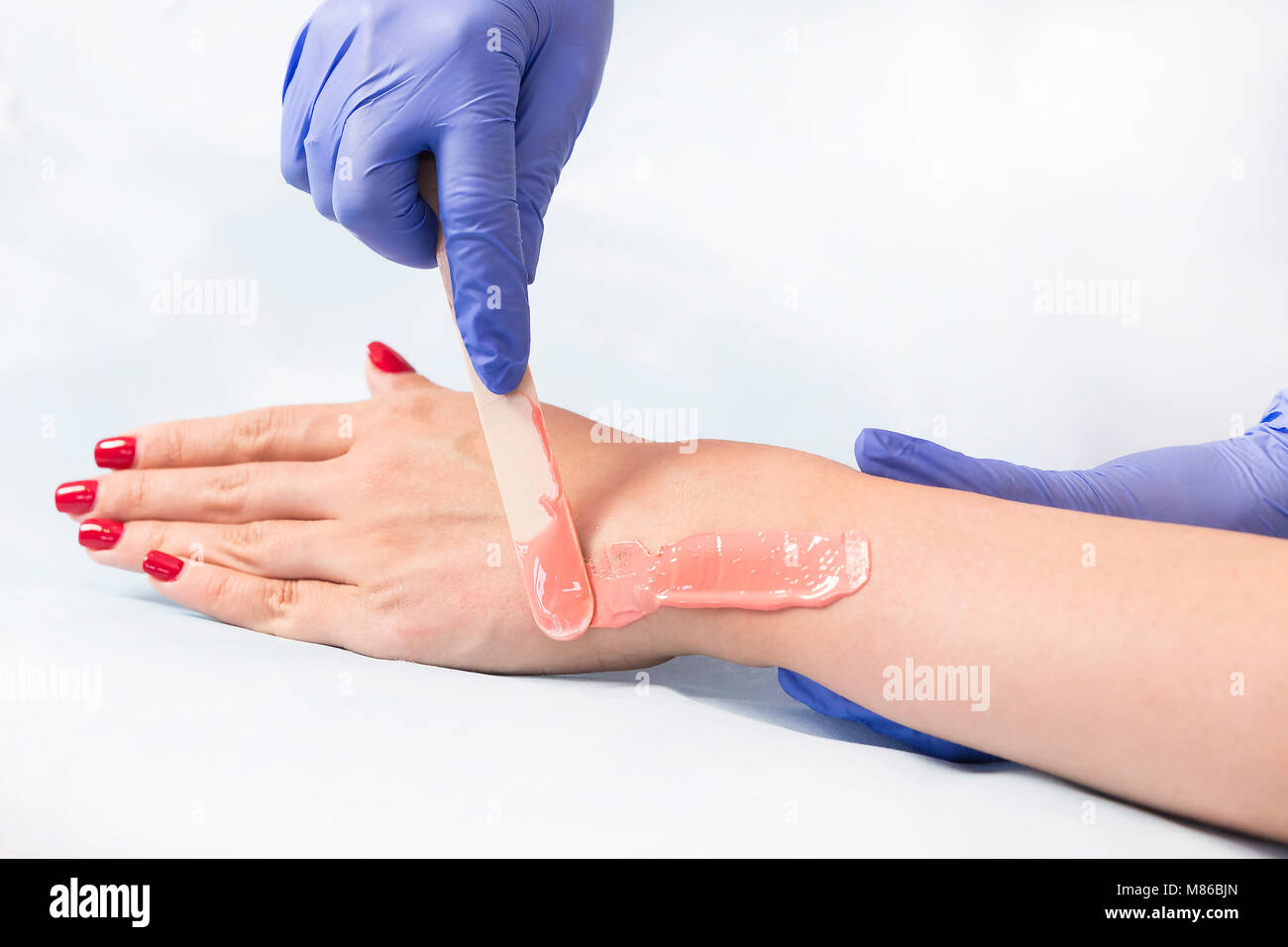 The process of classical wax depilation of female limbs in the beauty ...