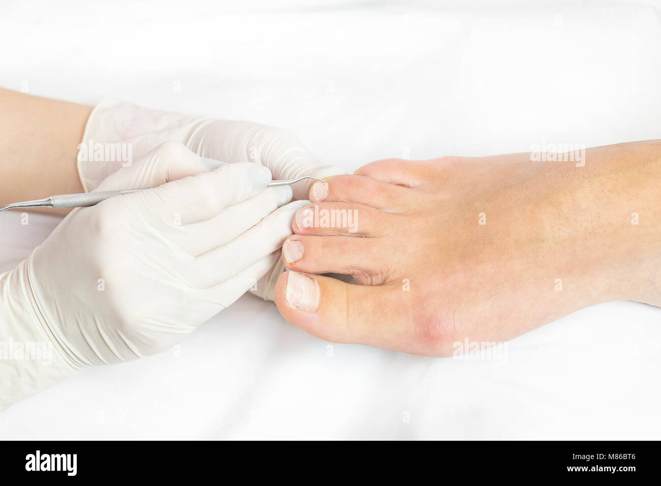 Female foot in the process of pedicure procedure in a beauty salon ...