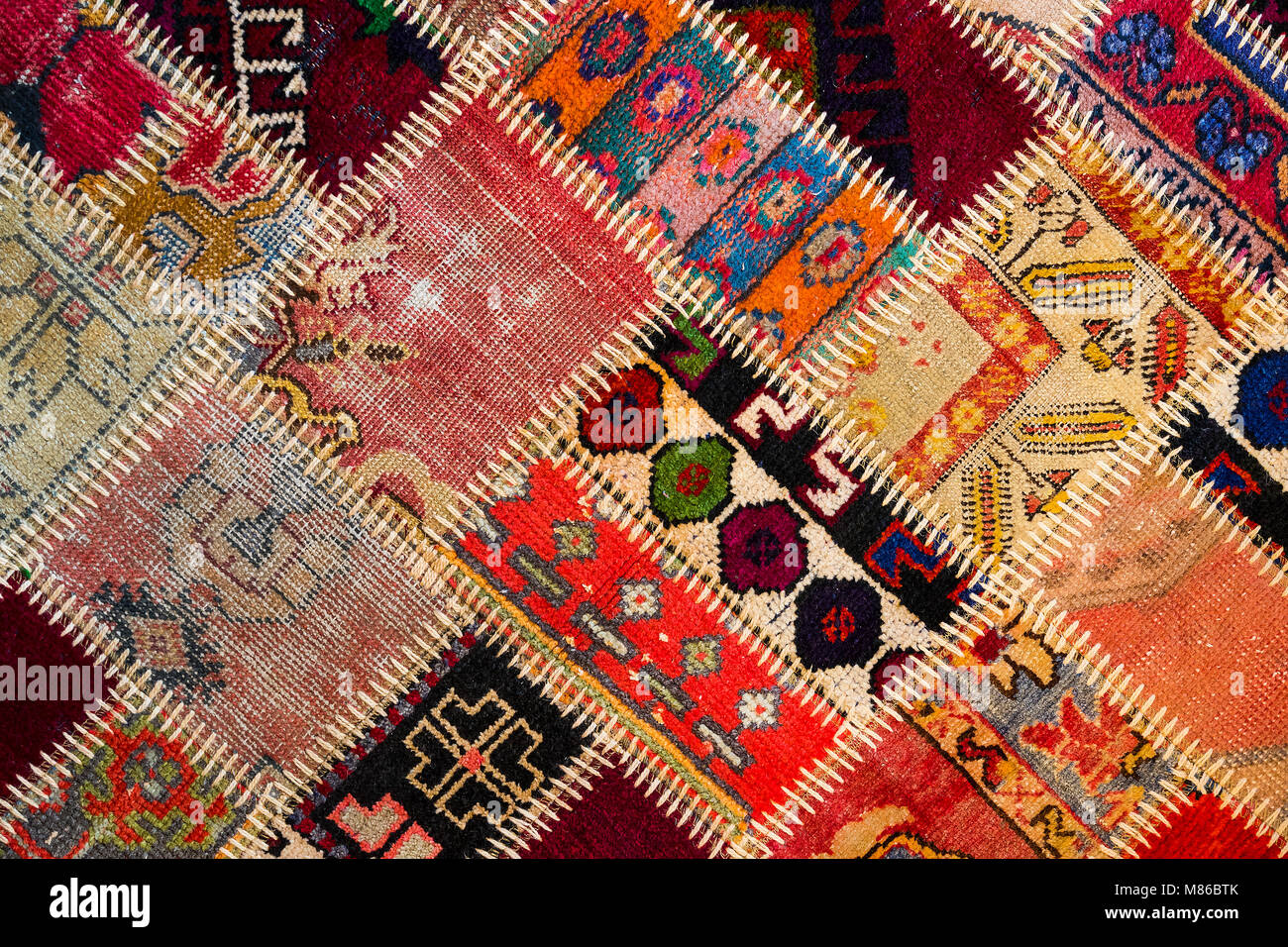 Background of an old worn carpet sewn with thick threads Stock Photo ...
